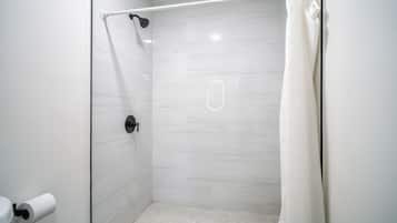 Chuveiro, toalhas de banho, sabonete, shampoo