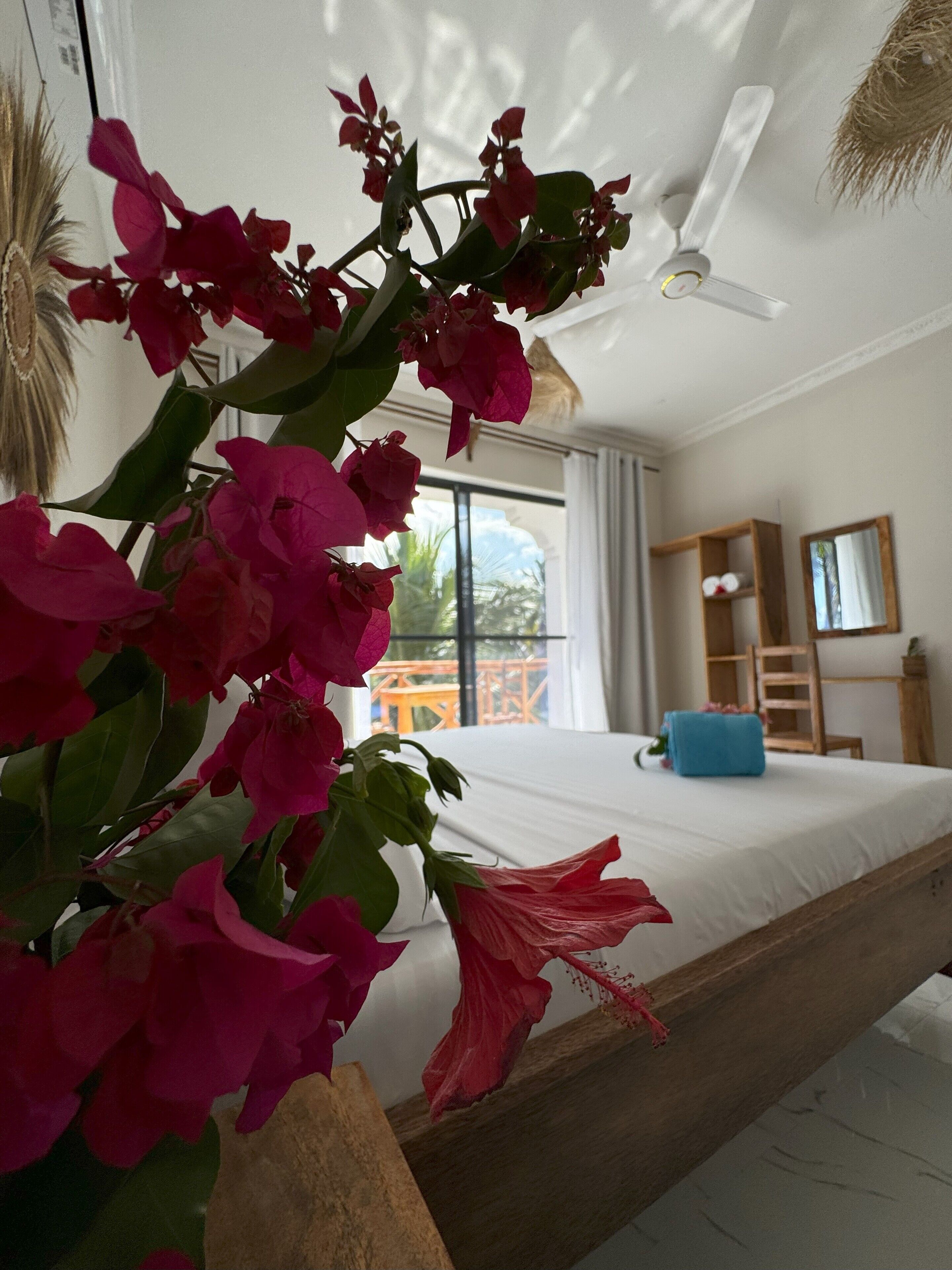 Quarto com uma cama, um ventilador de teto, uma janela e vista para o exterior.