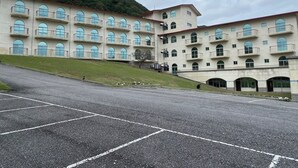 Um edifício espaçoso com várias varandas e janelas em arco, localizado numa encosta.