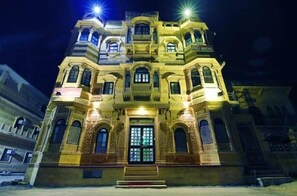Um edifício de vários andares com detalhes arquitetônicos elaborados e uma entrada imponente.