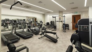 Uma academia com esteiras, elípticos e equipamentos de musculação.