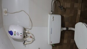 Casa de banho com sanita, bidé e lavatório fixo à parede.