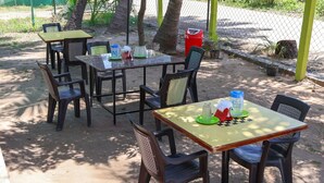 Mesa e cadeiras dispostas ao ar livre, com um número de mesa visível.