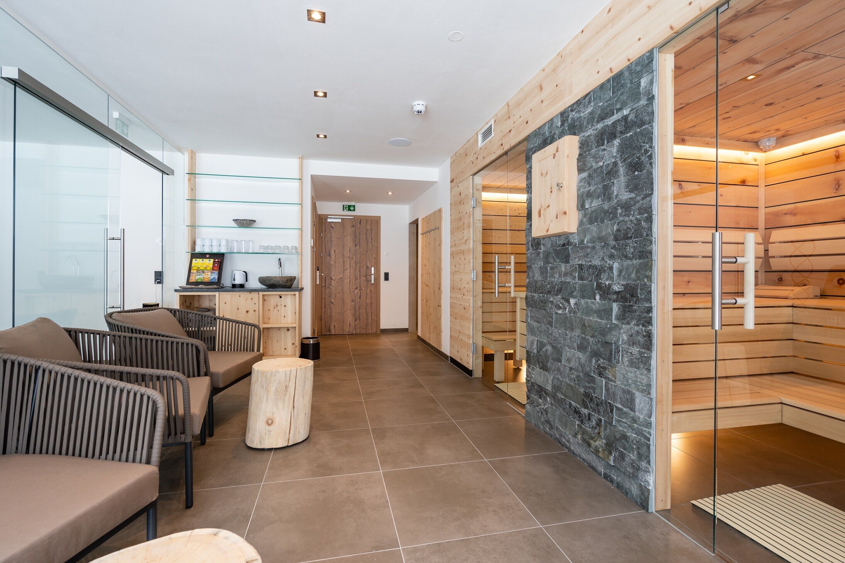 Interior moderno com assentos, área de recepção e sauna.