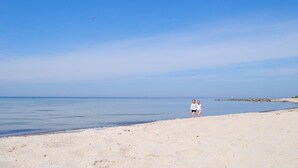Uma praia com céu claro e mar calmo.