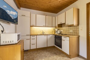Um frigorífico, um micro-ondas, um forno, uma placa de cozinha