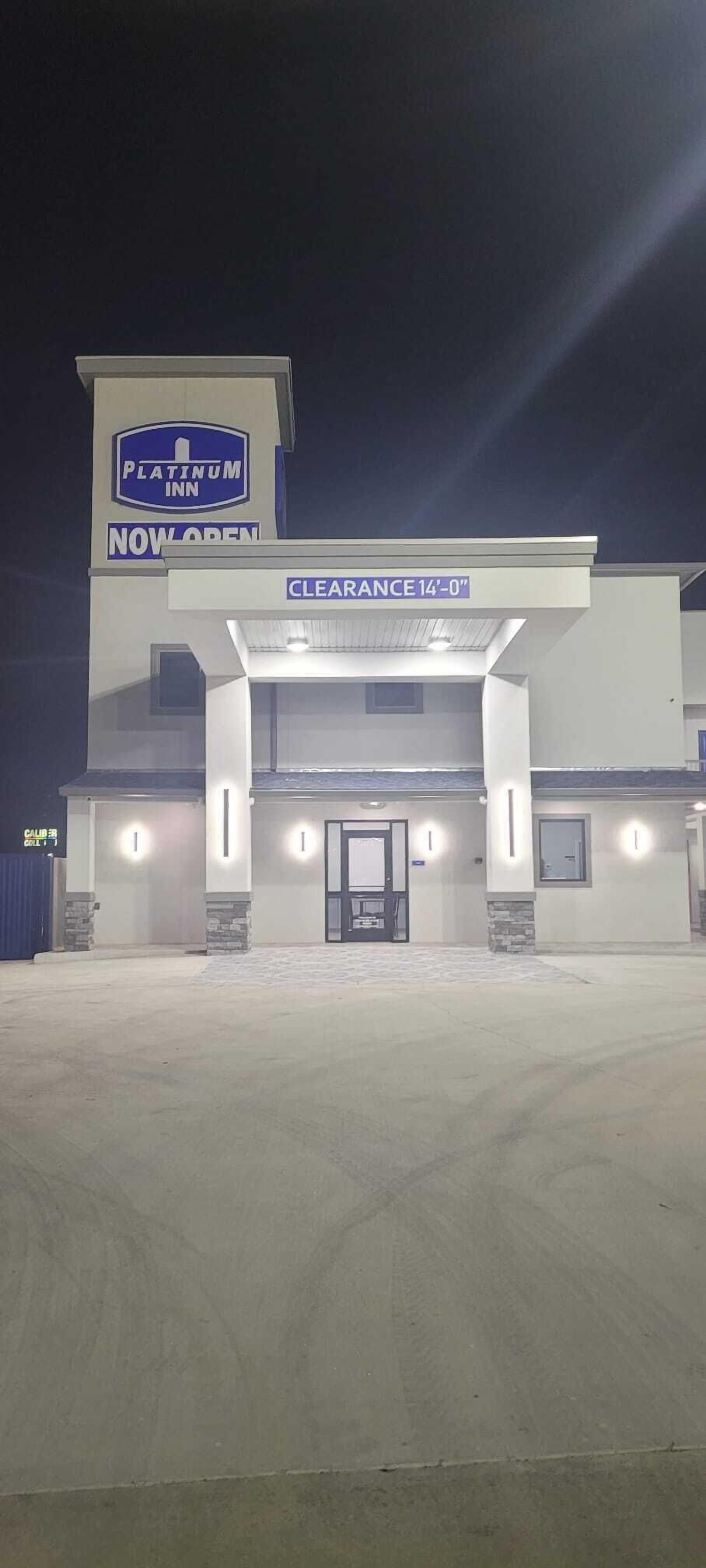 Entrada do hotel Platinum Inn com sinalização indicando 4,27 metros de altura.