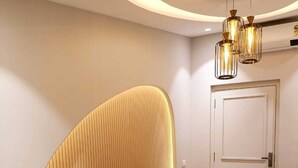 Uma sala de estar moderna com uma parede curva, dois sofás, uma mesa de centro e uma porta.