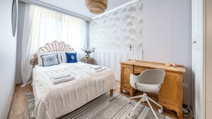 Quarto com cama, escrivaninha e cadeira.