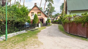 Rua residencial com casas, um caminho de cascalho e uma cerca de madeira.