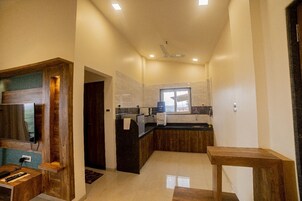 Cozinha moderna com armários de madeira, forno embutido e uma janela.