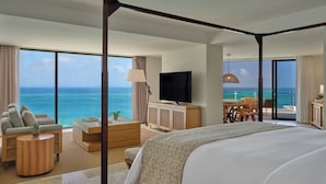Quarto espaçoso com uma cama grande, televisão e vista para o oceano.