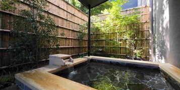 Um jardim japonês tradicional com lago de carpas, cerca de bambu e uma pequena cascata.