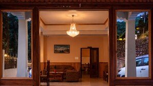 Um hall de entrada com teto de madeira, um candelabro, um sofá e uma mesa de jantar.
