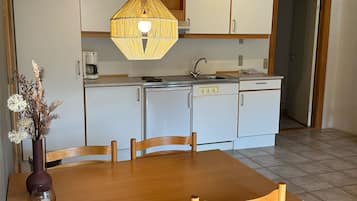 Minifrigorífico, um forno, uma placa de cozinha, uma cadeira de bebé