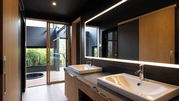 Uma casa de banho moderna com duas pias, um espelho grande e uma porta de vidro deslizante para uma varanda.