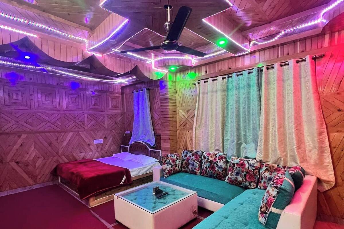 Quarto com teto de madeira, cama, sofá e mesa de centro.