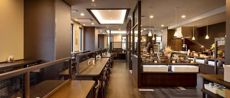 Um interior de restaurante moderno com mesas comunitárias longas, cabines individuais e uma área de buffet.