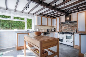 Cozinha moderna com armários de madeira, painel de backsplash de pedra e eletrodomésticos embutidos.