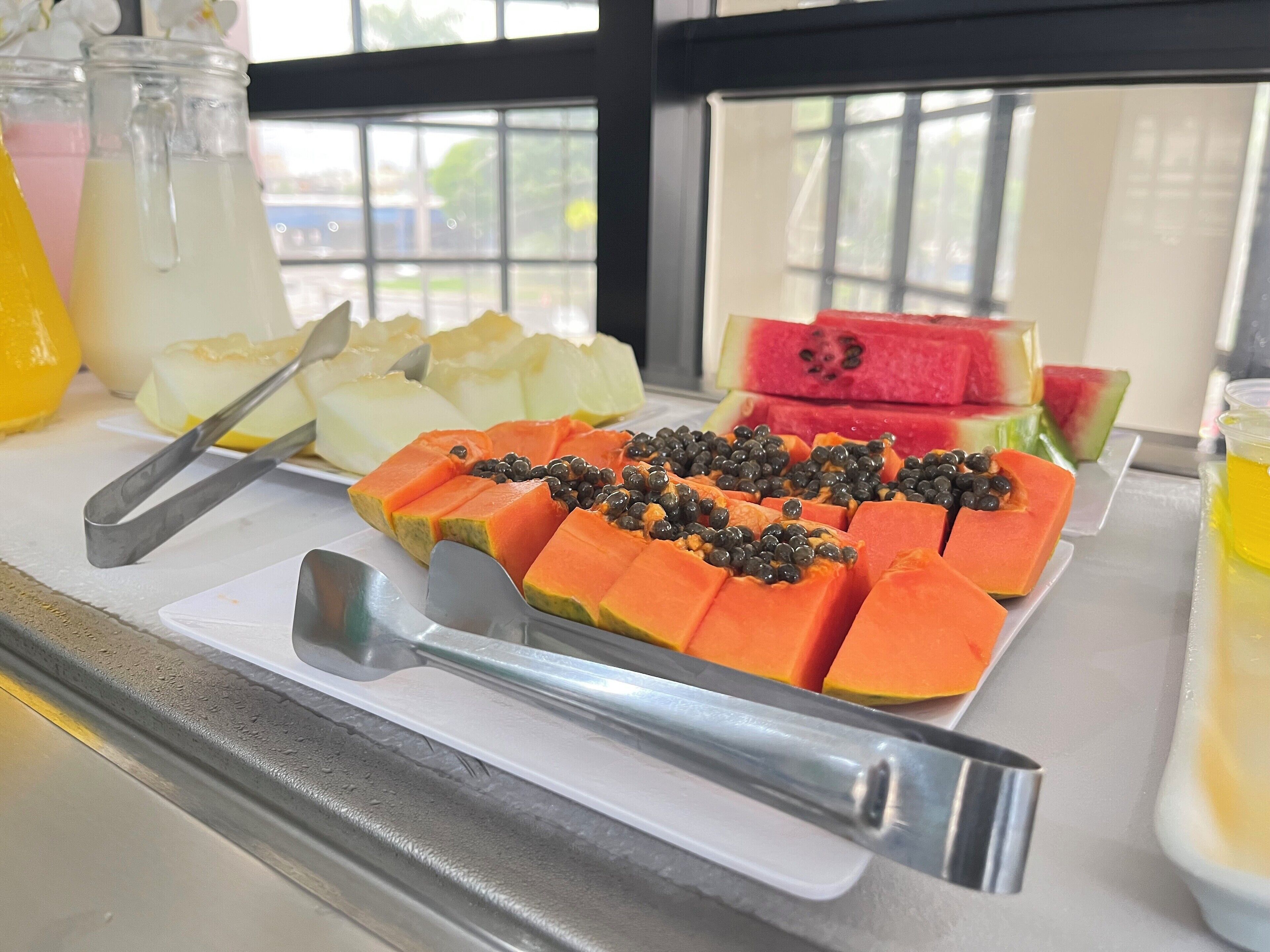 Um prato de frutas variadas e uma faca sobre uma mesa.