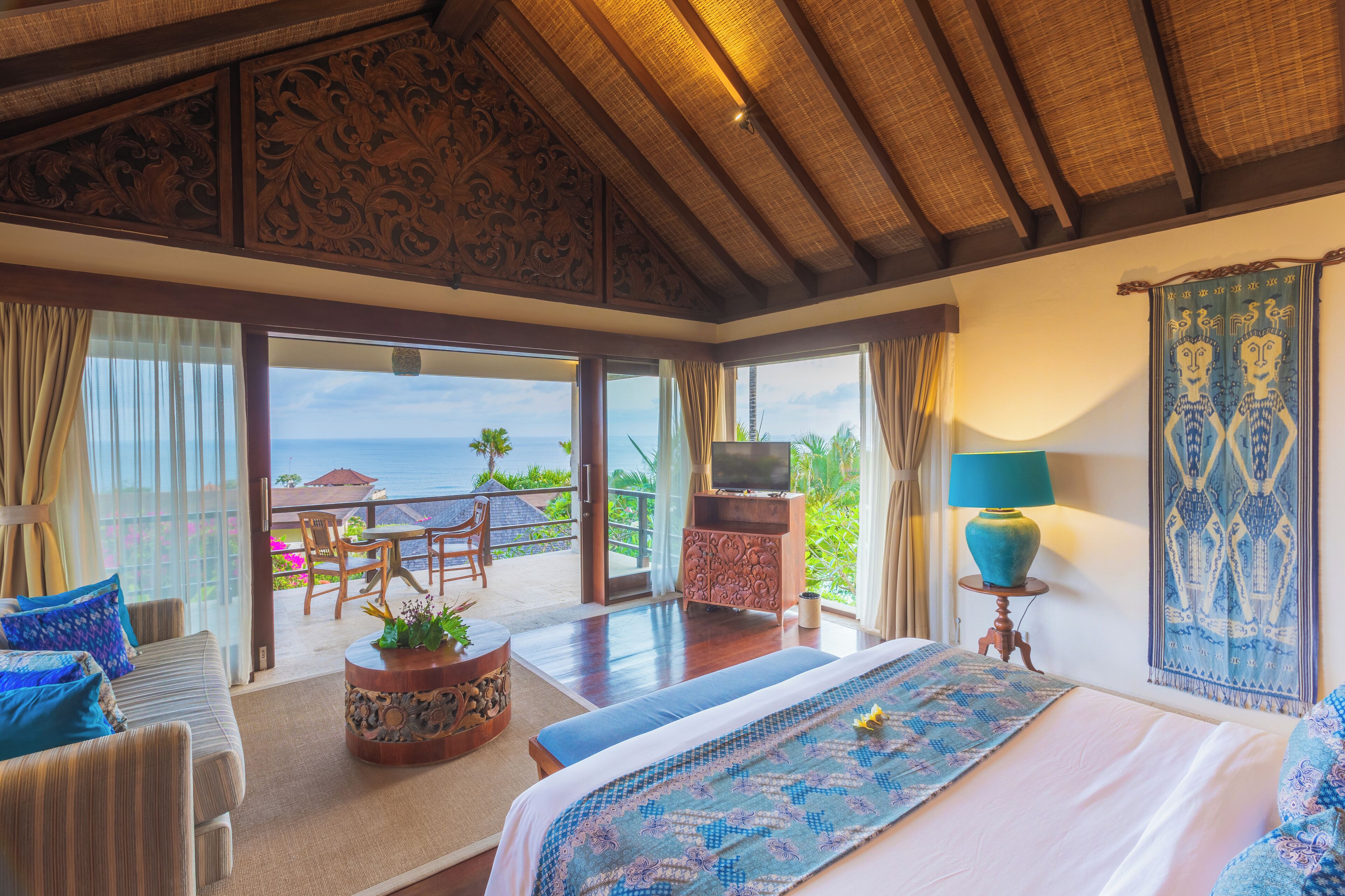Um quarto amplo com uma cama grande, televisão e vista para o oceano.