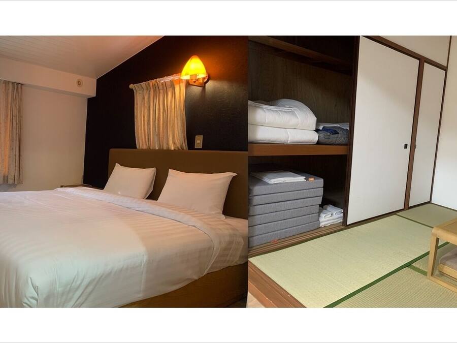 Quarto de hotel com cama, mesa de cabeceira, luminária, guarda-roupa e um futon.