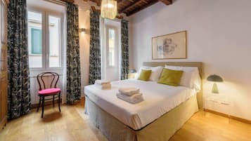 Quarto com cama, cadeira, mesa de cabeceira e abajur.
