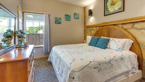 Quarto com cama grande, penteadeira e janela com cortinas.