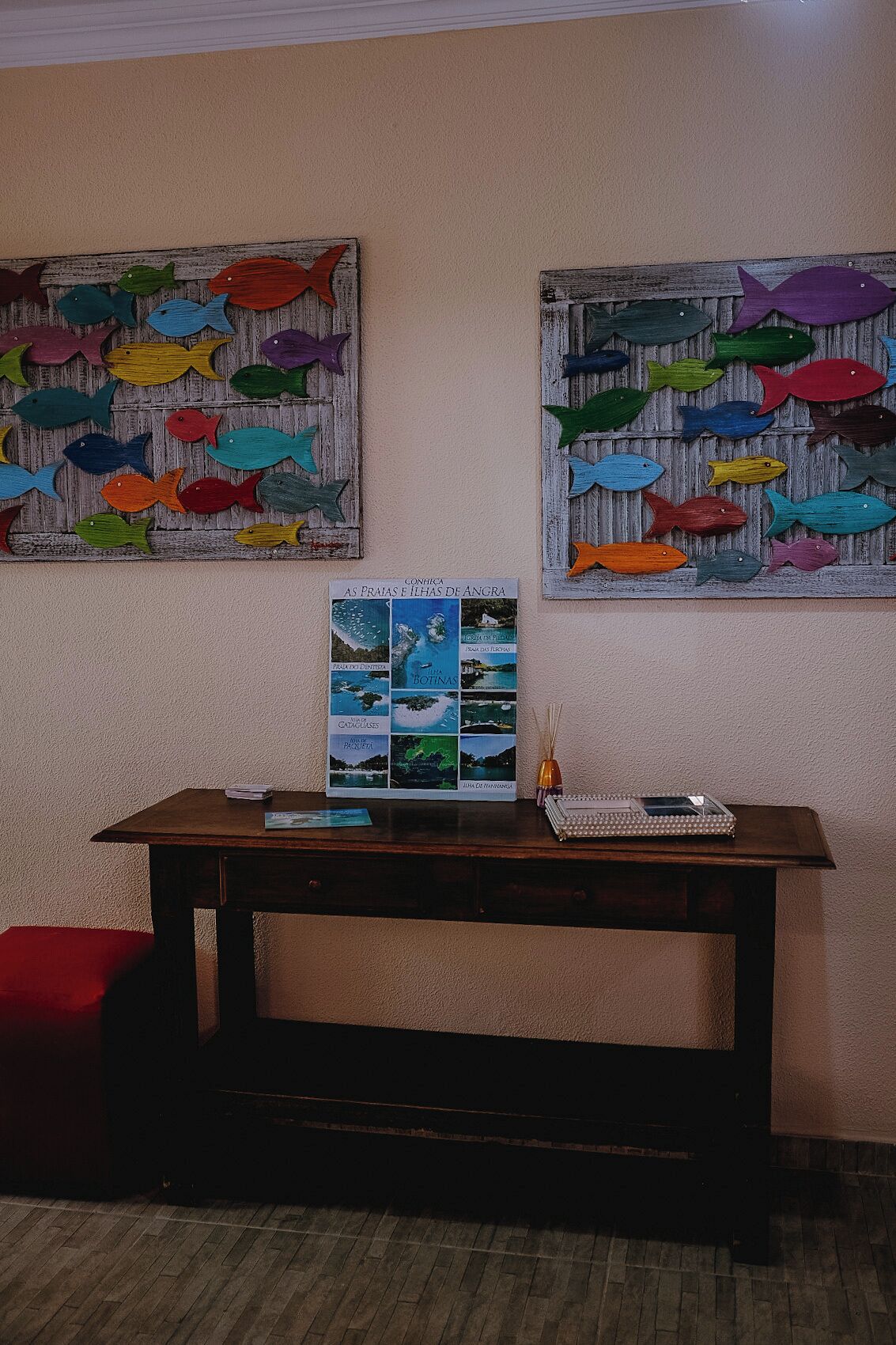 Uma mesa de madeira com uma colagem de fotografias emolduradas e um objeto decorativo pequeno.