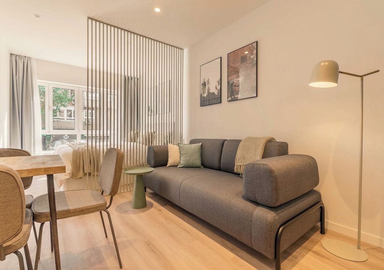 Uma sala de estar moderna com sofá, cadeiras, mesa de jantar e abajur.