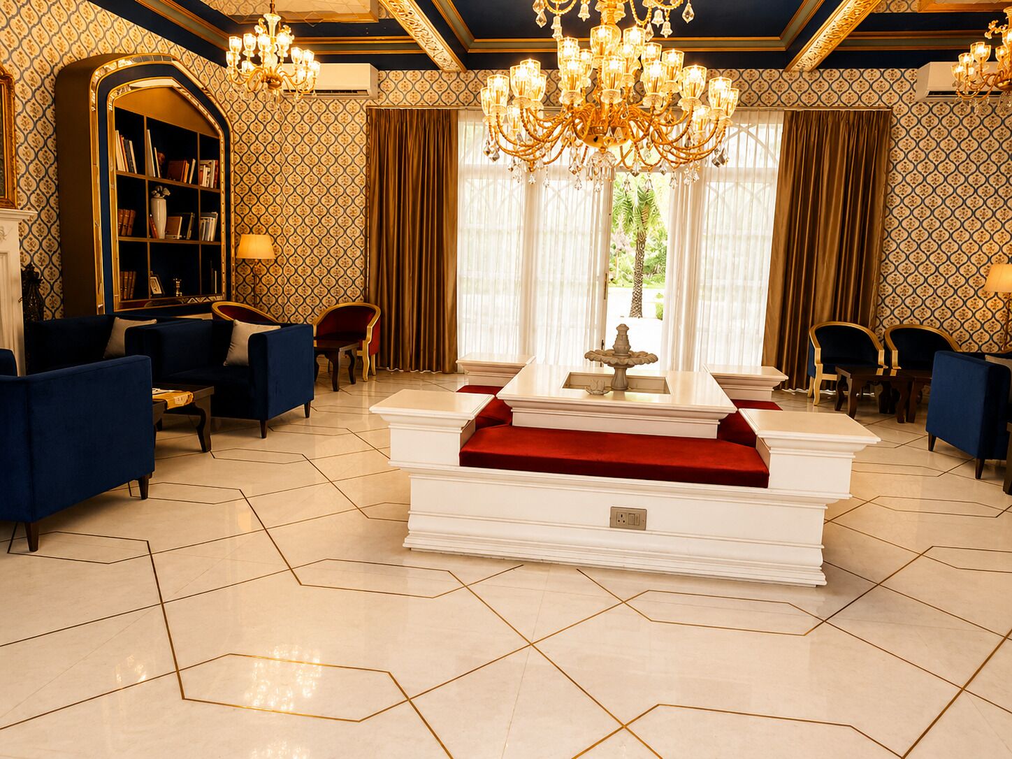 Um saguão de hotel com área de estar central, um lustre e papel de parede estampado.