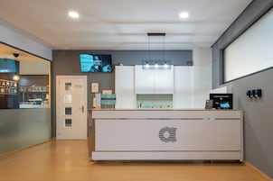 Uma cozinha moderna com uma ilha central, forno embutido e televisão na parede.
