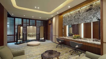 Um interior moderno com área de estar, toucador com espelho e parede decorativa.