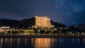 Um hotel grande e iluminado com design moderno, localizado à beira-mar.