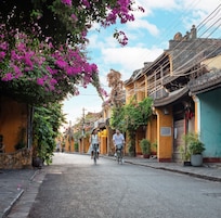Uma rua estreita ladeada por edifícios tradicionais, alguns com varandas e detalhes decorativos.