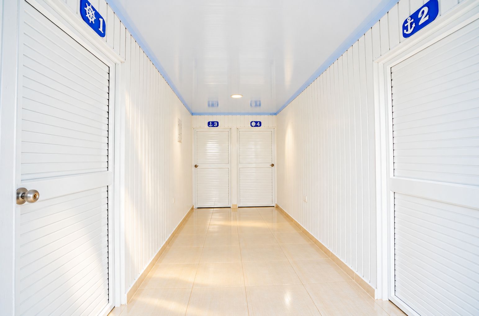 Um corredor com portas fechadas, cada uma identificada com um número.