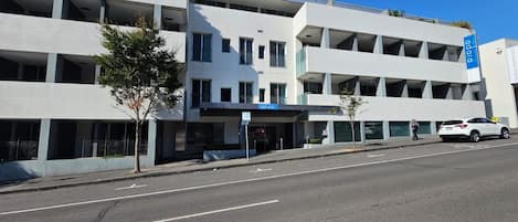 Um edifício moderno de vários andares com fachada plana, janelas grandes e uma placa com 'adara'.