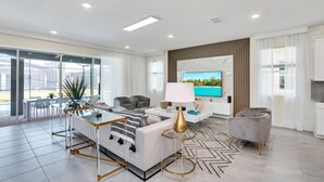 Uma sala de estar moderna com um sofá, poltronas, uma mesa de centro e uma televisão.
