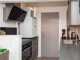 Cozinha moderna com forno embutido, micro-ondas e cafeteira.