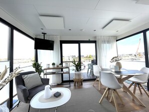 Uma sala de estar moderna com sofá, mesa de centro e área de jantar.