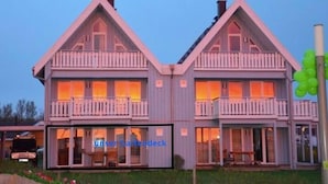Uma casa de dois andares com uma varanda no andar superior.
