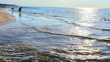 Uma praia com água cristalina e areal arenoso.