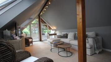 Uma sala de estar moderna no estilo loft, com teto alto, janelas amplas e uma área de estar aconchegante.
