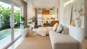 Uma sala de estar moderna com um sofá, uma mesa de centro e uma grande janela com vista para um jardim.