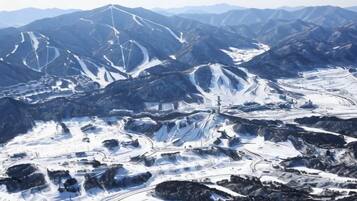 Paisagem montanhosa coberta de neve com pistas de esqui.