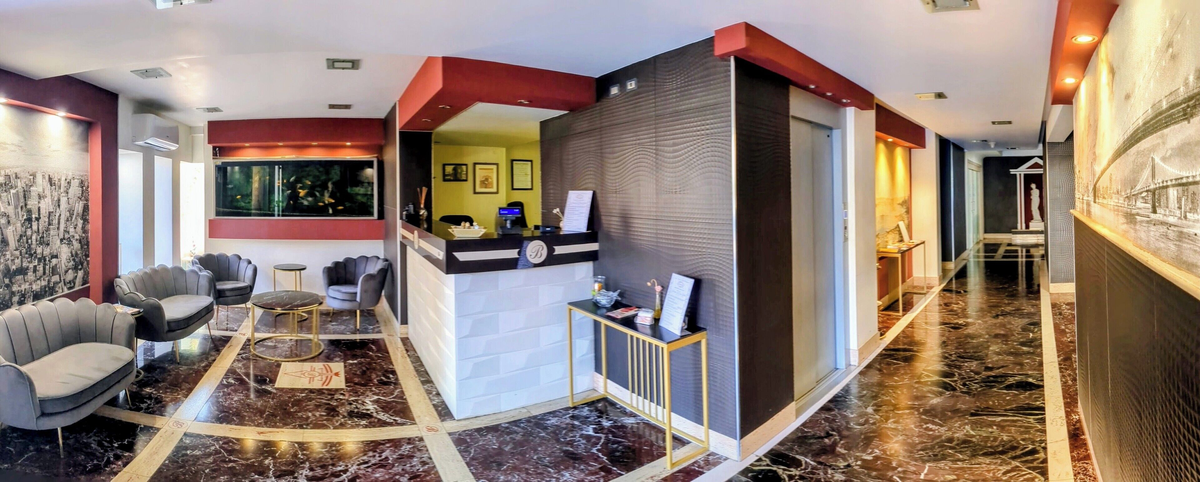Um hall moderno com balcão de recepção, área de estar e piso de mármore.