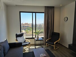Apartamento família, 2 quartos, sacada, vista para a cidade | Área de estar | Smart TV 55 polegadas com canais via satélite