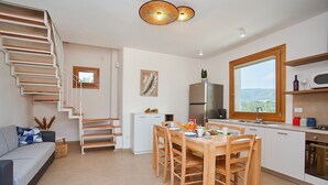 Cozinha moderna com área de refeições, escada e vista para o exterior.