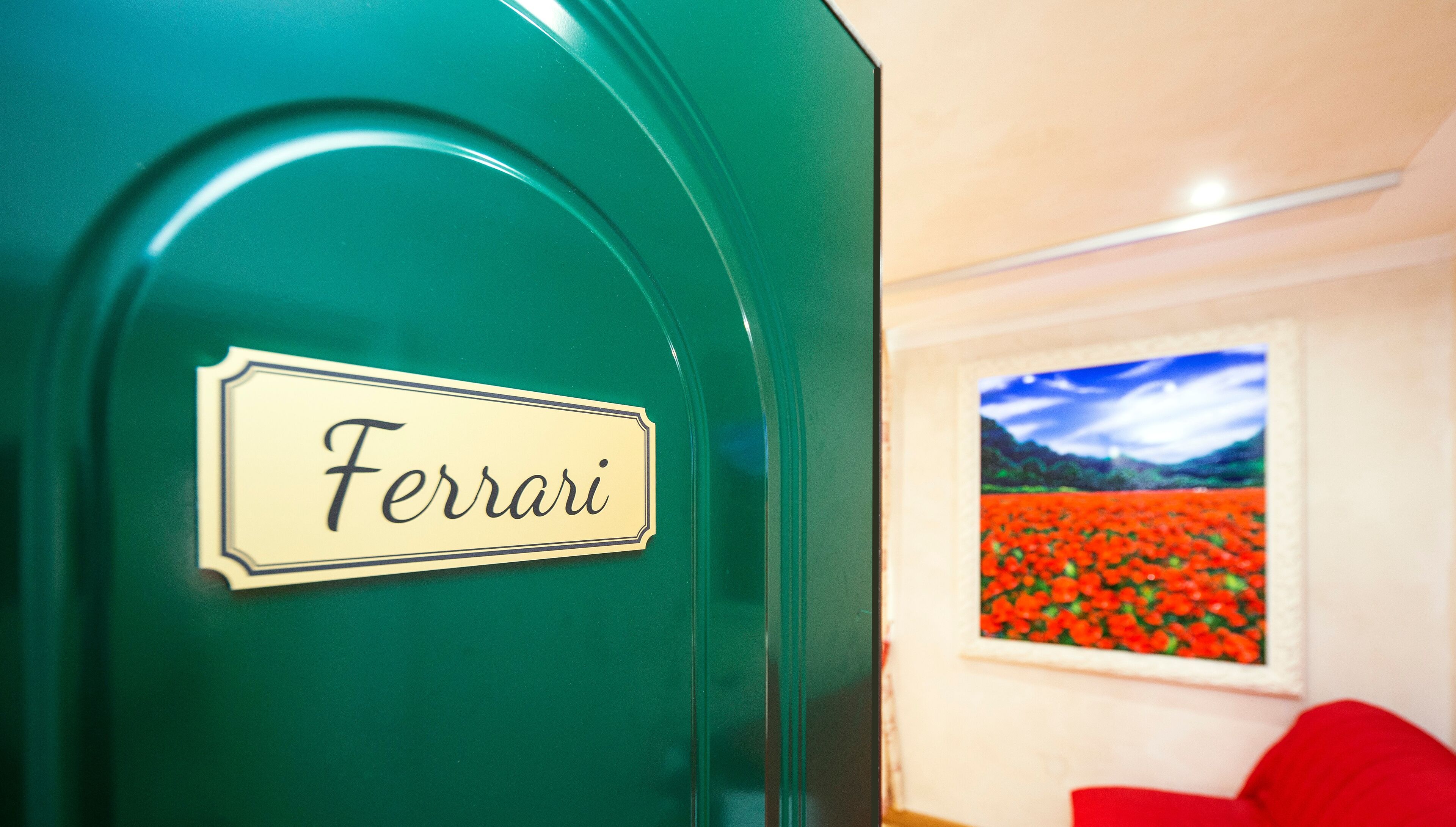 Uma porta verde com uma placa que diz 'Ferrari'.