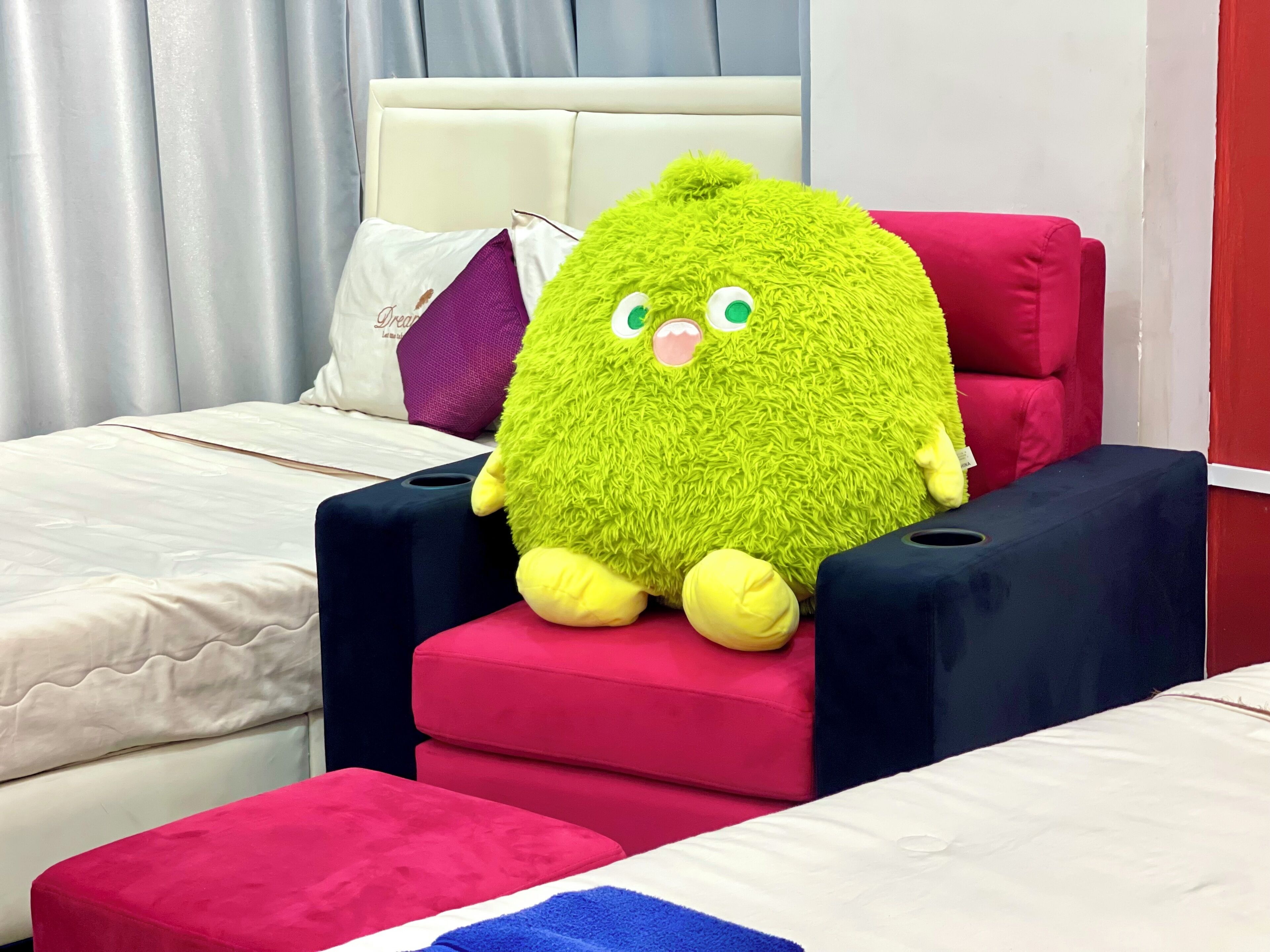 Uma cama com um brinquedo de pelúcia, um travesseiro e uma mesinha de cabeceira.